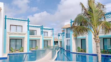 Um resort com vários edifícios em azul e branco, uma piscina central e áreas de estar ao ar livre.