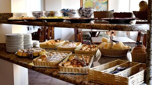Disposição de buffet com diversos alimentos e utensílios à mostra.