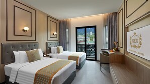 Quarto de hotel com duas camas, varanda e vista, e um balcão de recepção.