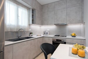 Apartamento superior, 2 quartos | Cozinha privada | Geladeira, cooktop, chaleira elétrica
