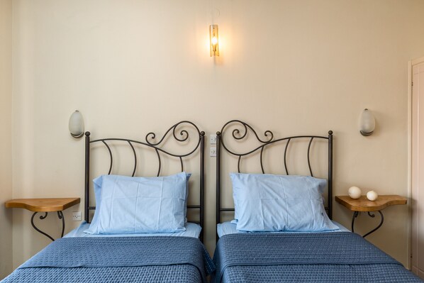 Uma cama de casal com cabeceira, mesa de cabeceira e luminária na parede.