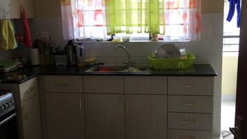 Apartamento, 3 quartos | Cozinha privada | Um frigorífico, um micro-ondas, um forno, uma placa de cozinha