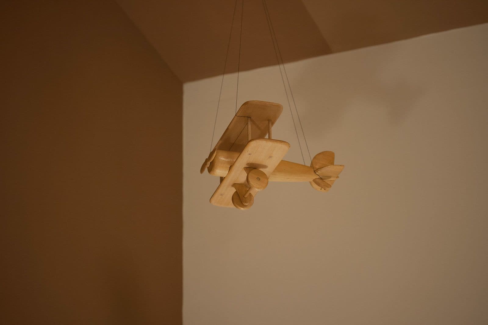 Um avião de madeira em miniatura pendurado no teto.