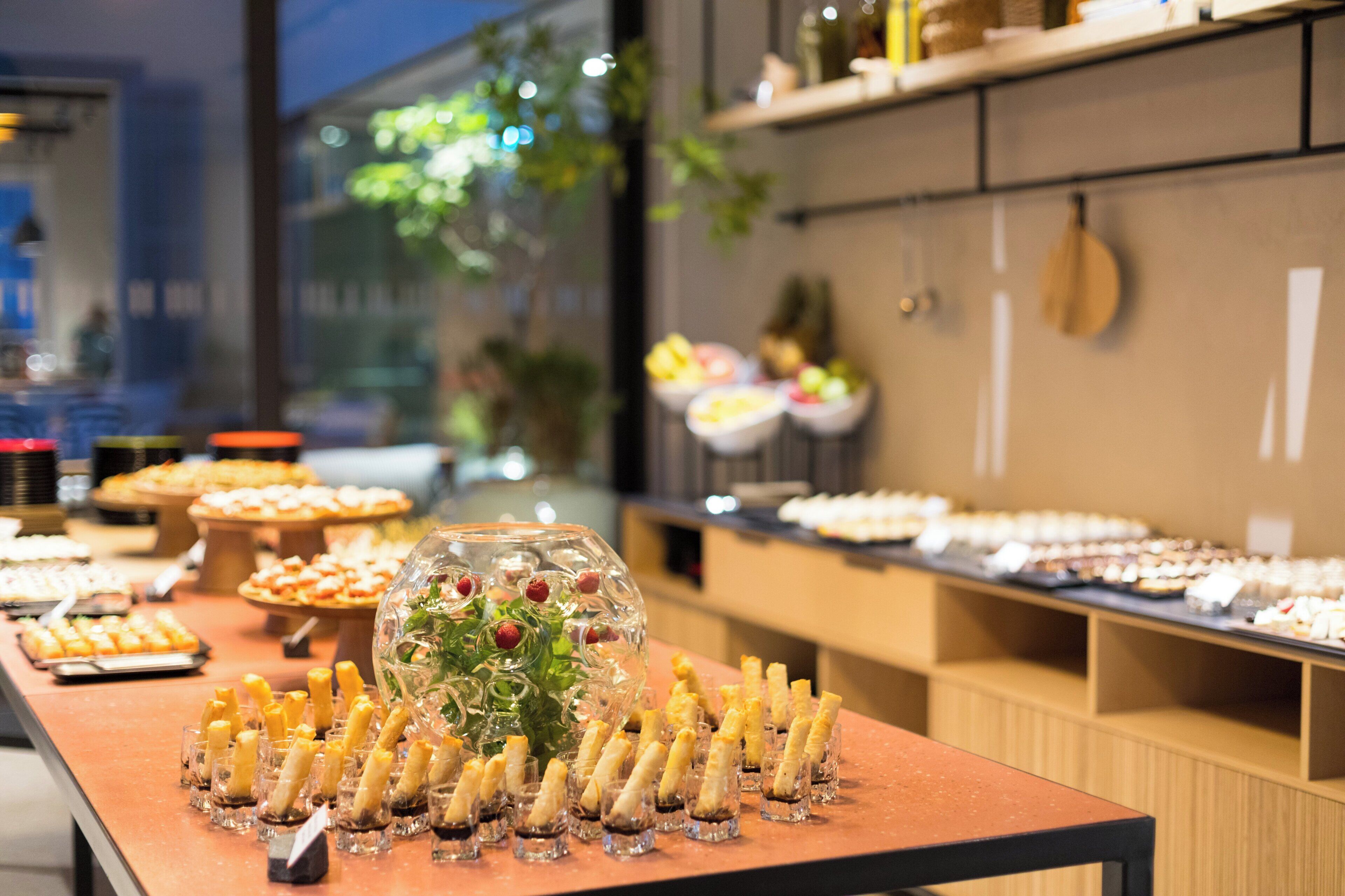 Um buffet com diversos alimentos e um centro de mesa decorativo.