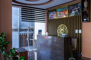 Uma receção com design tradicional, uma janela ampla com persianas e uma parede decorativa com obras de arte cultural.