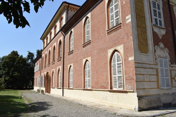 Um edifício histórico com janelas em arco e fachada de tijolos.