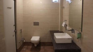Casa de banho com sanita, lavatório e espelho.