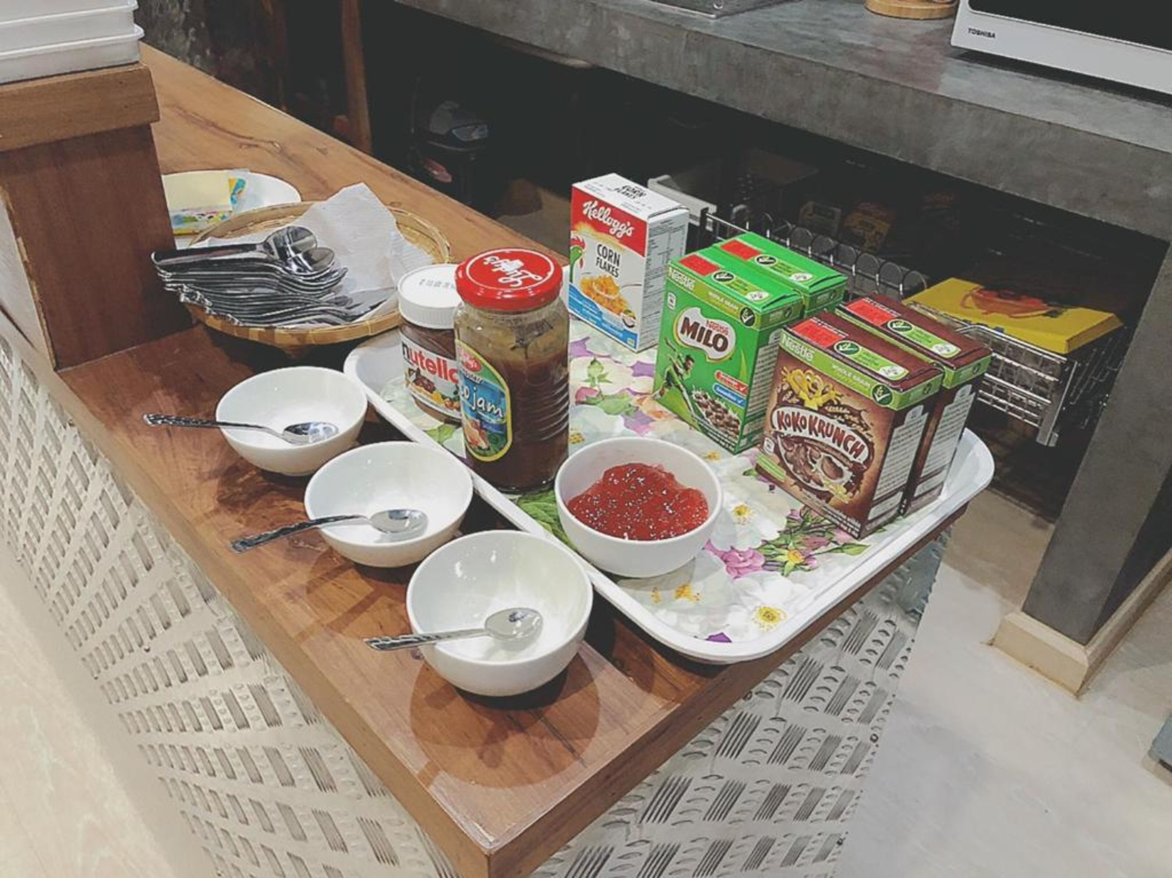Uma bancada de cozinha com diversos alimentos e temperos, incluindo potes de geleia e caixas de cereal.