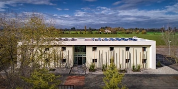 Um edifício moderno com telhado plano, painéis solares e fachada simétrica.