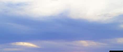 Pôr do sol com céu limpo e silhueta de um edifício.