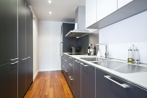 Apartamento luxo, 1 quarto | Cozinha privada | Geladeira grande, micro-ondas, fogão, cooktop