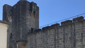 Pátio com parede de pedra e uma mesa branca com uma cadeira.