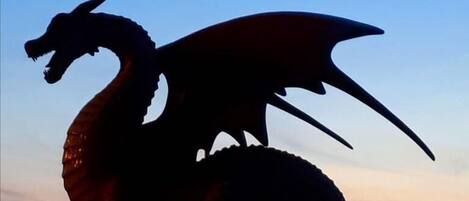 Silhueta de dragão contra um céu crepuscular.