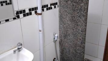 Um banheiro com pia branca, vaso sanitário e box de chuveiro.