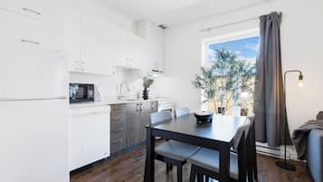 Estúdio Deluxe, 1 cama queen-size e sofá-cama, pátio, Vista para a cidade (Mont-Royal 301) | Refeições no quarto
