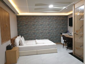 Quarto moderno com cama, mesa de cabeceira e escrivaninha com cadeira.