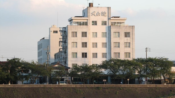 Um edifício de vários andares com telhado plano e uma placa escrita em outro idioma.