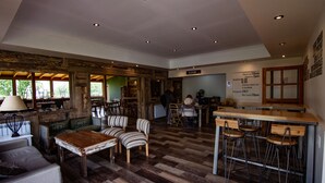 Decoração rústica com área de bar, assentos e balcão de recepção.