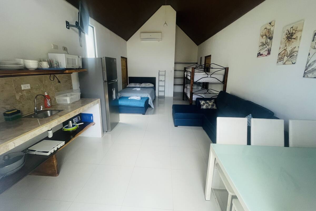 Um espaço compacto com cozinha compacta, área de refeições e beliche.