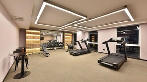 Uma academia moderna com esteiras, bicicletas ergométricas e máquinas de musculação.
