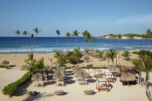Perto da praia, areia branca, espreguiçadeiras, guarda-sóis 