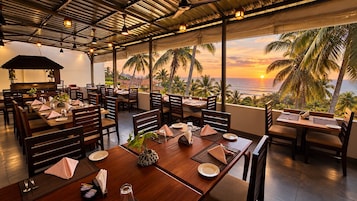 Um restaurante com várias mesas e cadeiras, algumas decoradas com plantas e guardanapos.