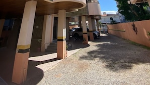 Um edifício com design arquitetônico único, com varandas cilíndricas e um pátio de cascalho.