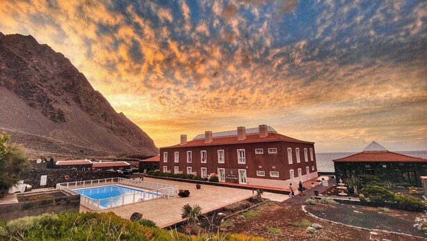 Um edifício grande com piscina e vista para o mar.