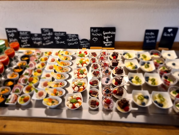 Diversos alimentos dispostos em uma bandeja, com etiquetas indicando os diferentes tipos de pratos.