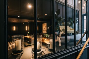 Quarto com uma janela grande, uma mesa com velas e vista para o exterior.