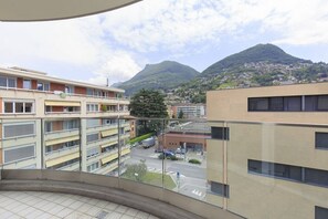 Vista de varanda com vista para a cidade e montanhas ao fundo.