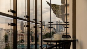 Vista da cidade a partir de uma varanda com mesa e cadeiras.