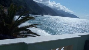 Uma varanda com vista para o mar e montanhas.