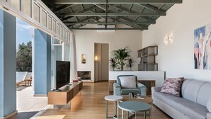 Uma sala de estar moderna com televisão, sofás e mesa de centro.