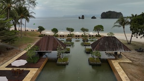 Um resort com área de piscina, espreguiçadeiras e vista para a praia e o oceano.