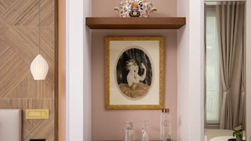 Um banheiro moderno com parede de madeira, uma obra de arte emoldurada, uma prateleira com objetos decorativos e um espelho refletindo uma janela com cortinas.