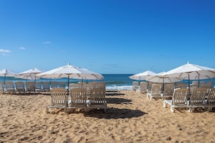 Uma praia privada, espreguiçadeiras, guarda-sóis de praia