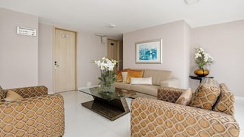 Uma sala de estar moderna com um conjunto de sofás, uma mesa de centro e um quadro na parede.