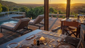 Uma área de refeições com uma mesa posta para dois, com vista para uma paisagem deslumbrante.