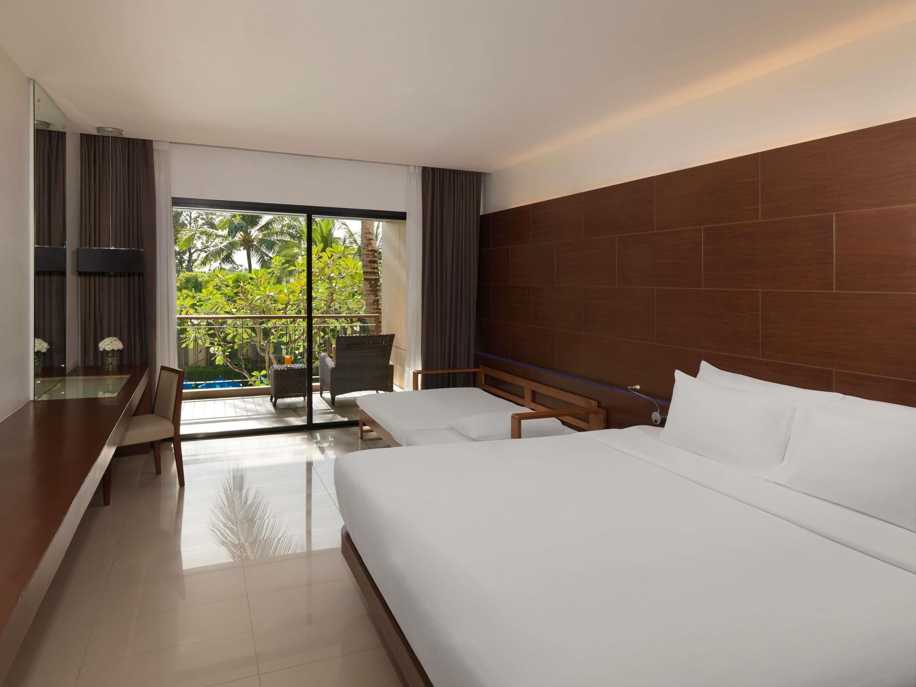 Quarto Deluxe, varanda, vista para a piscina (1 King Bed and 1 Sofabed) | Edredões de penas, cofre no quarto, secretária 