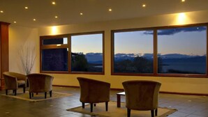 Quarto espaçoso com grandes janelas e vista para uma paisagem montanhosa.