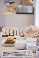 Uma mesa de buffet com diversos alimentos e utensílios de servir.