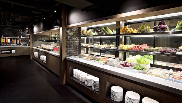Uma área de buffet com diversos alimentos e acompanhamentos.
