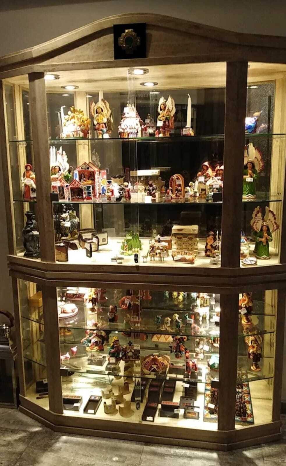 Vitrine de vidro em vários níveis, com várias figuras e objetos decorativos.