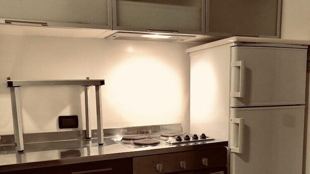 Cozinha compacta com fogão, forno e geladeira.