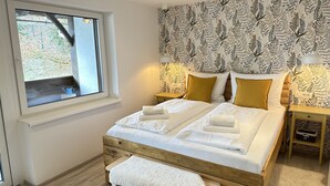 Quarto com uma cama grande, uma janela e papel de parede estampado.