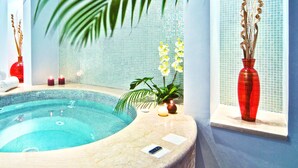Uma área de spa com hidromassagem, uma janela com um vaso vermelho e uma parede revestida de azulejos.