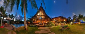Um resort com piscina, um gazebo e uma área de refeições coberta.