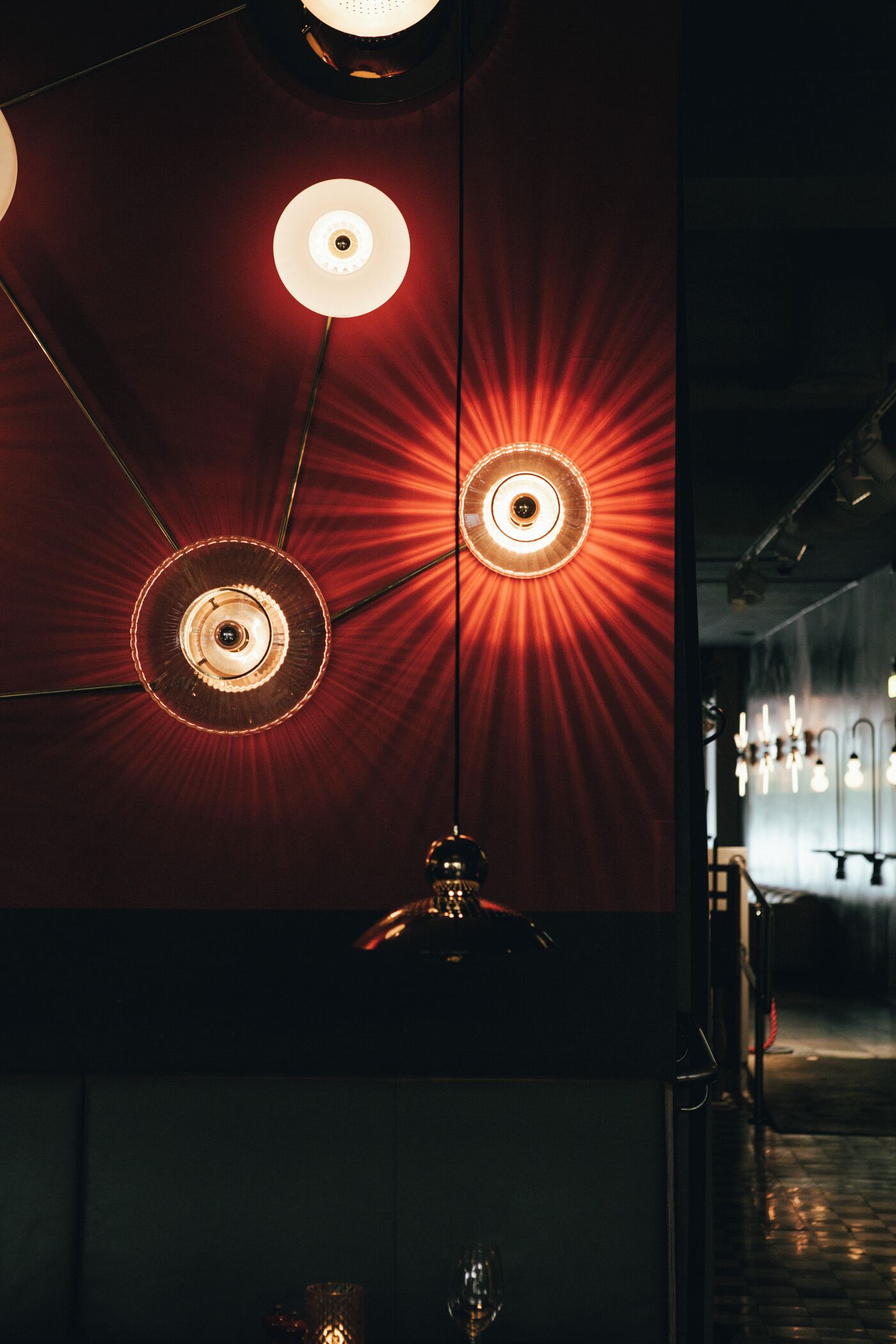 Um interior moderno com iluminação pendente e superfície refletora.