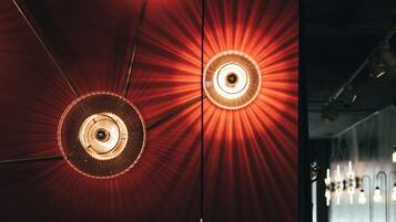 Um interior moderno com iluminação pendente e superfície refletora.